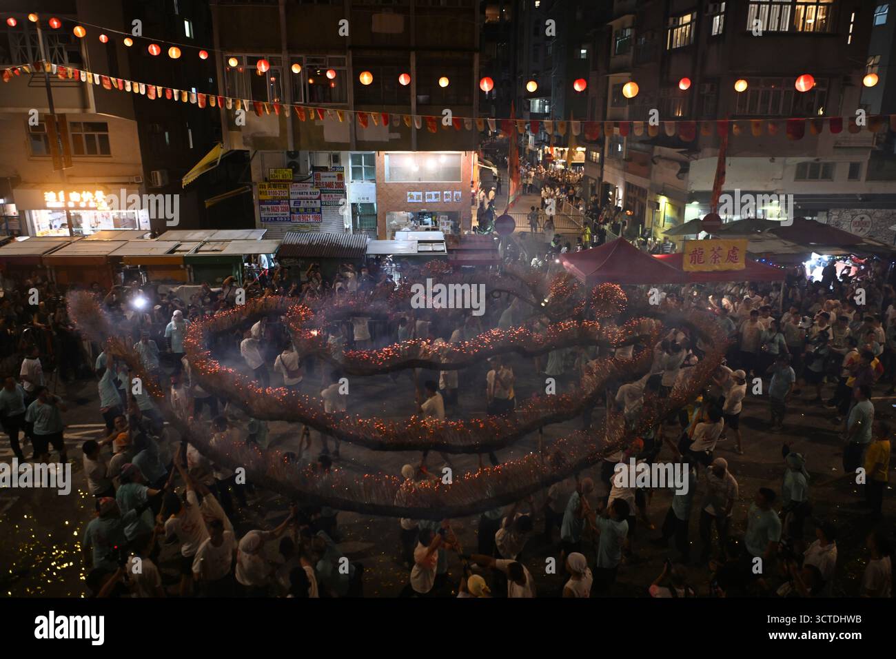 Performers holding up a fire dragon made up of burning incense sticks ...