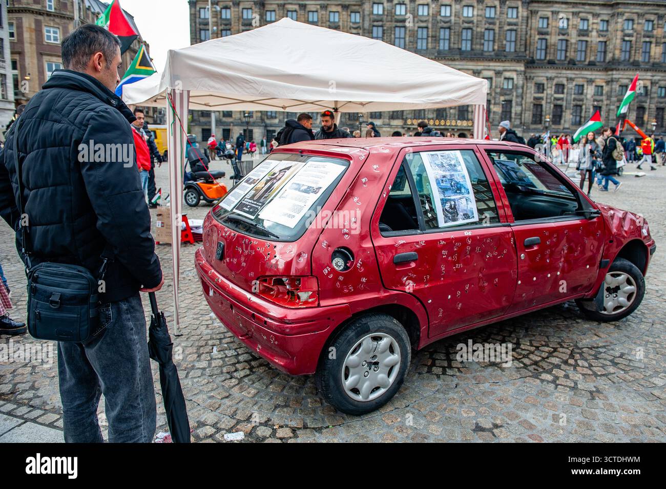 A man observing the car full of bullets. A vehicle representing five ...