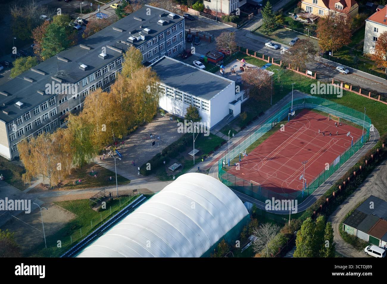 Aerial drone photograph of modern sports complex featuring red running ...