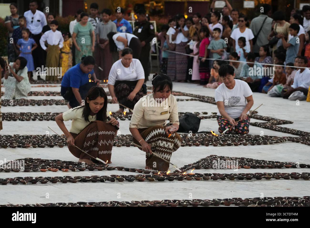 Buddhist devotees light oil lamps at Botataung pagoda during ...