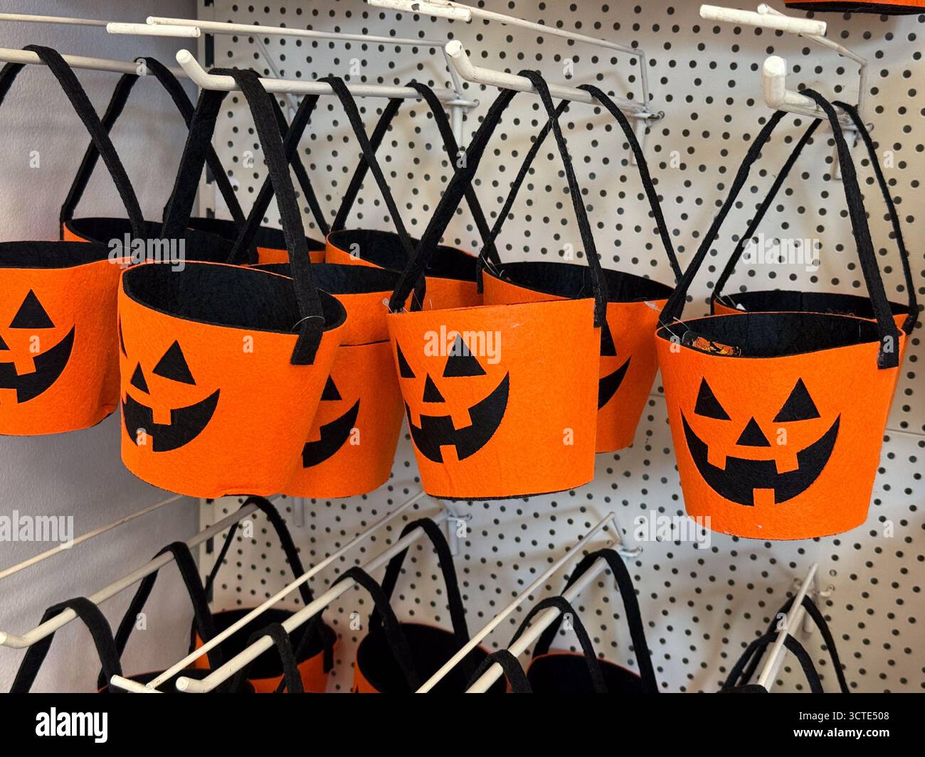 Orange felt buckets with jack o lantern faces and black handles on ...