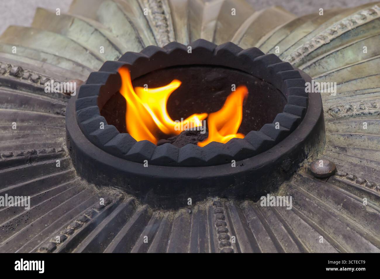 Detailed view of an eternal flame burning inside a circular metal ...