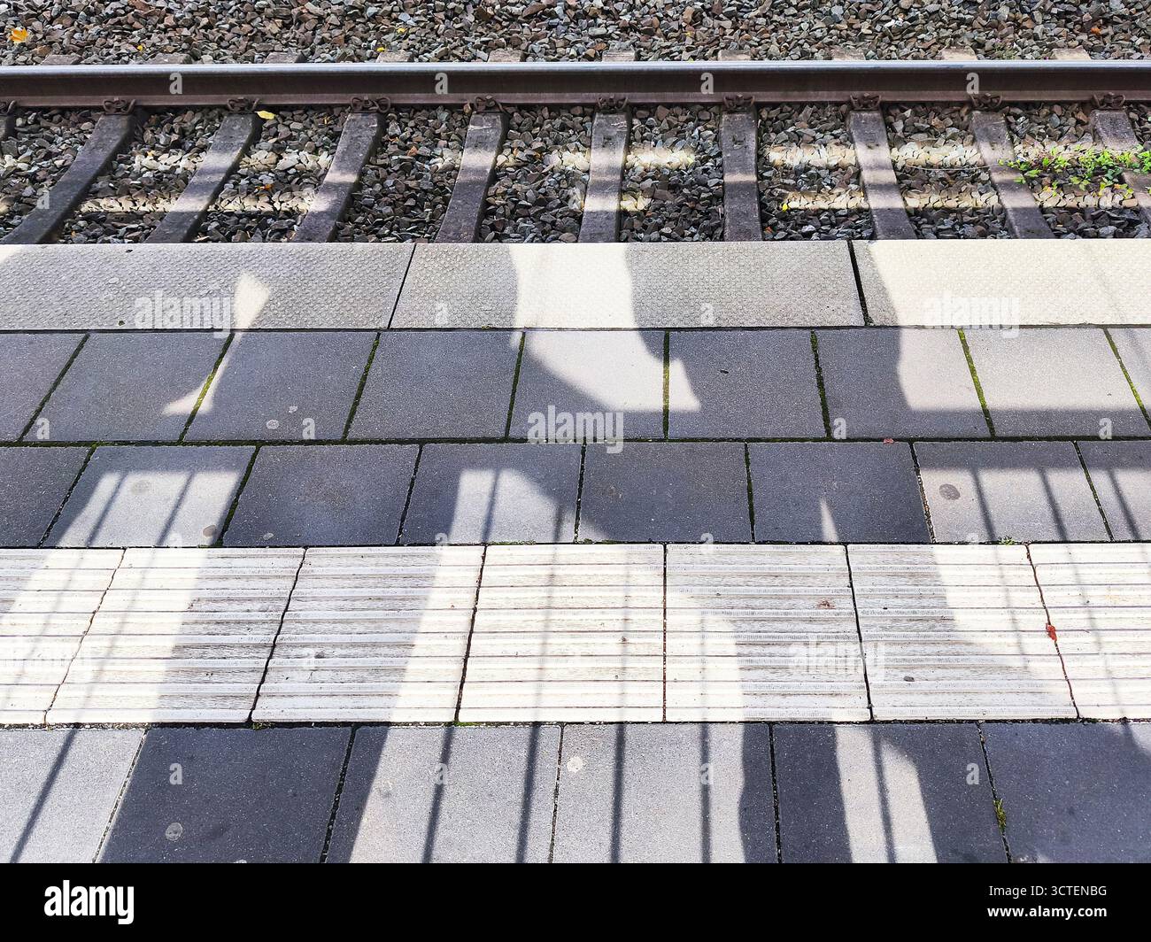 Long shadows of people waiting for a train on a railway platform Stock ...