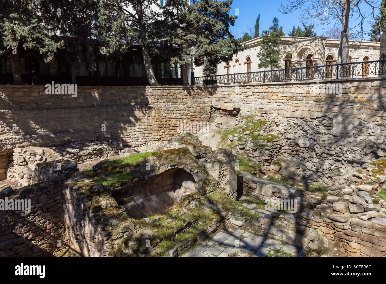 A historic stone ruin beside a raised courtyard in Baku, Azerbaijan ...