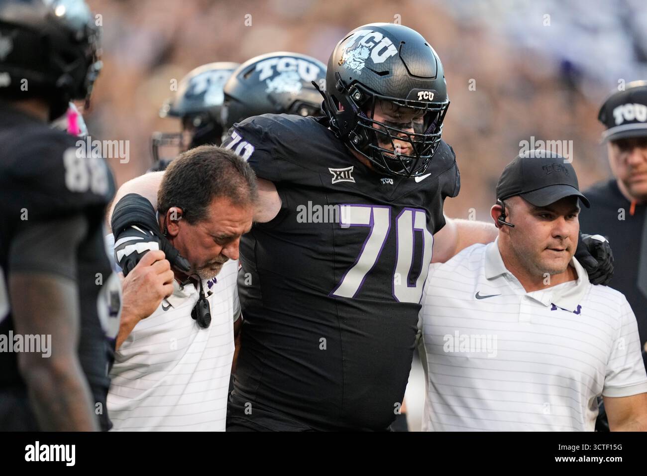 TCU offensive lineman Ryan Hughes (70) is assisted off the field after ...