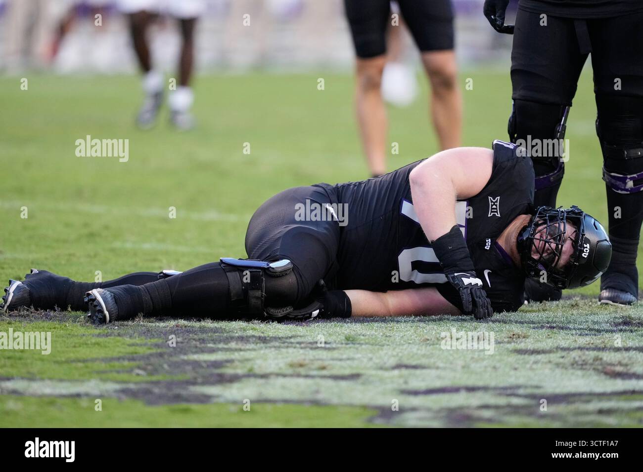 TCU offensive lineman Ryan Hughes (70) waits for medical attention from ...
