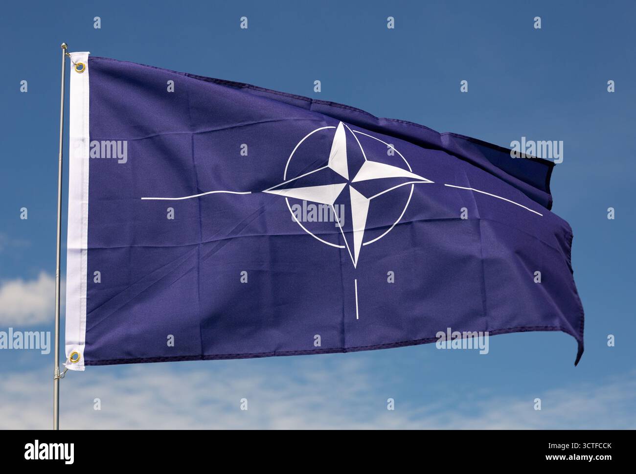 Dark blue flag of NATO waving against clear sky Stock Photo - Alamy