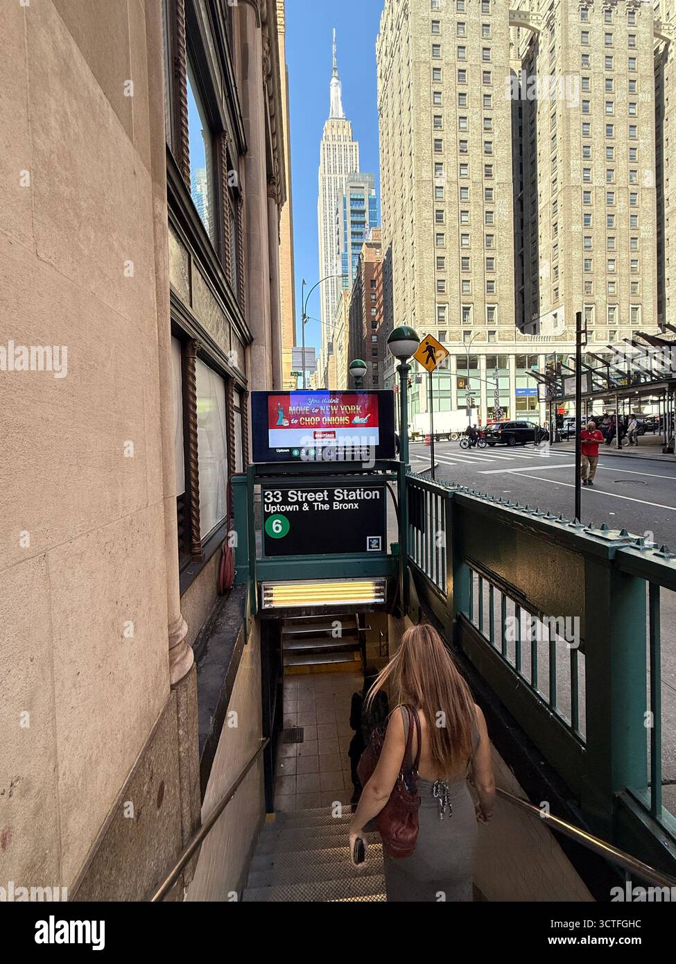 33rd Street 6 train entrance with the Empire State Building luming up ...