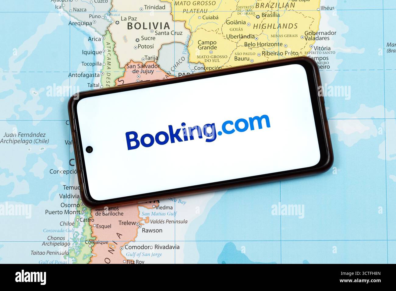 Close up to an a smart phone with a blue booking com logo over the ...