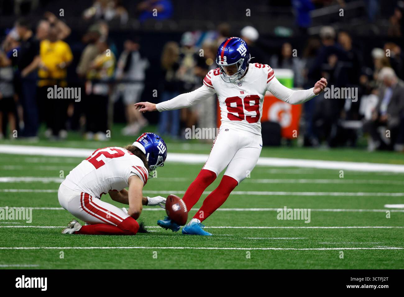 New York Giants kicker Jude McAtamney (99) kicks as Jamie Gillan (12 ...