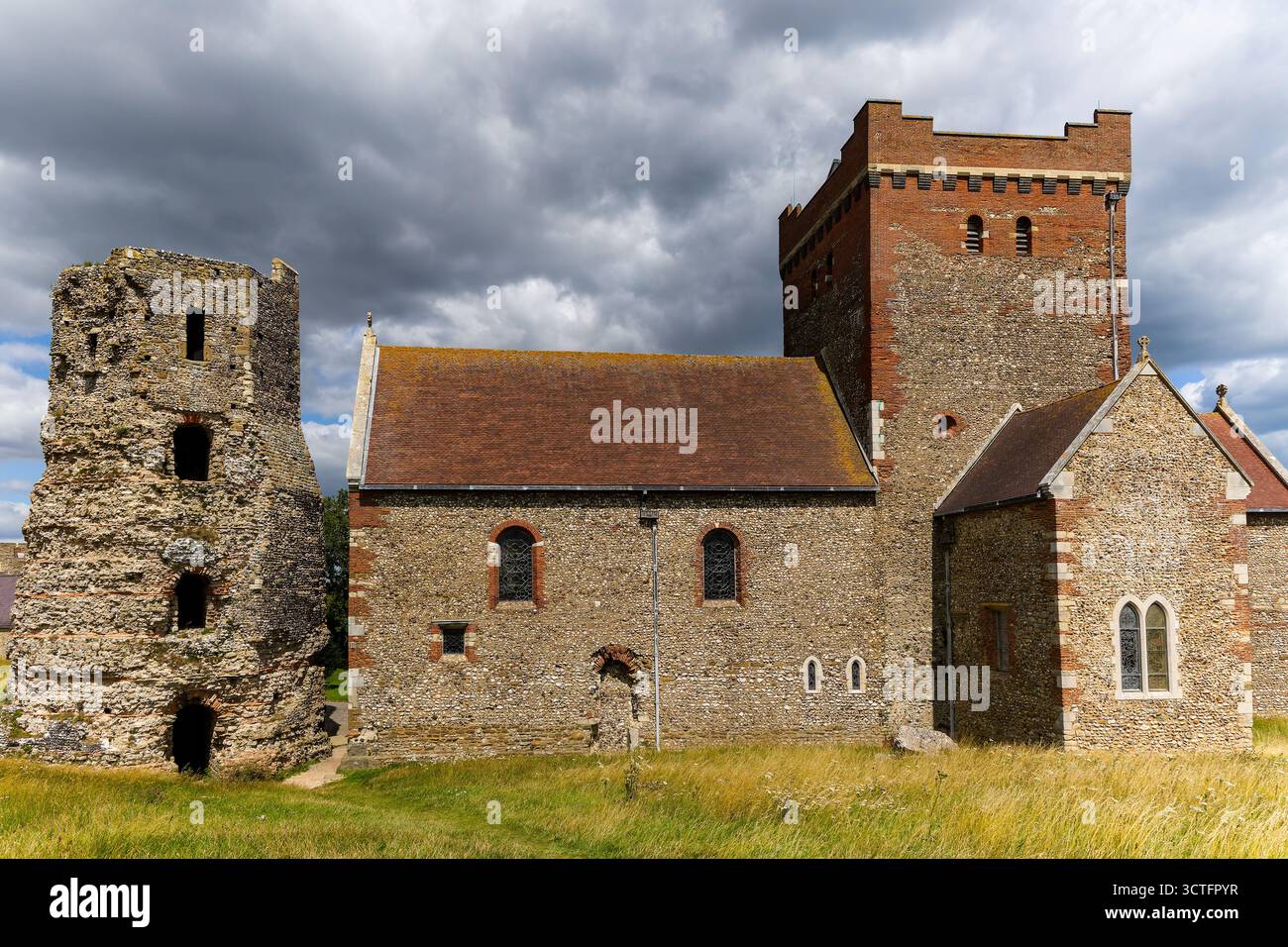 Dramatic cloudy sky over the ancient Saxon church and Roman lighthouse ...