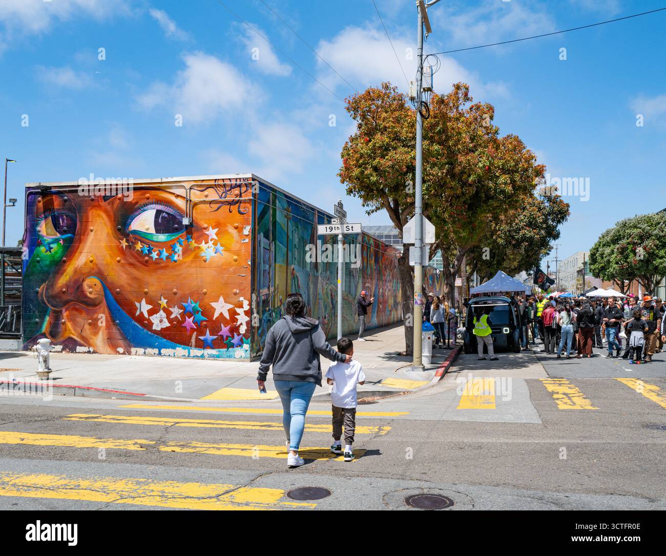 San Francisco, CA - U.S.A. - May 24, 2025: A mother and child cross ...