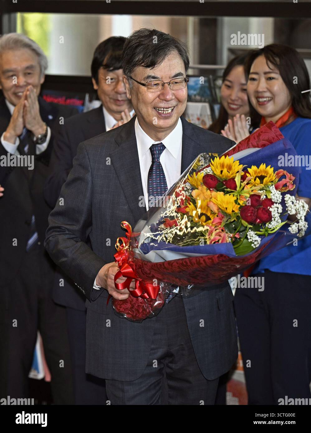 Osaka University professor Dr. Shimon Sakaguchi smiles as he receives flowers in Suita, near ...
