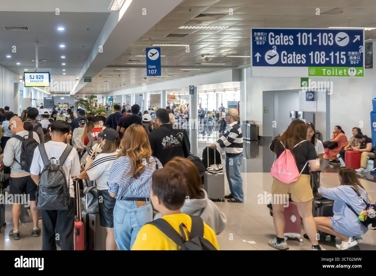 Travelers waiting in line in waiting area, Cebu Pacific Air gates ...