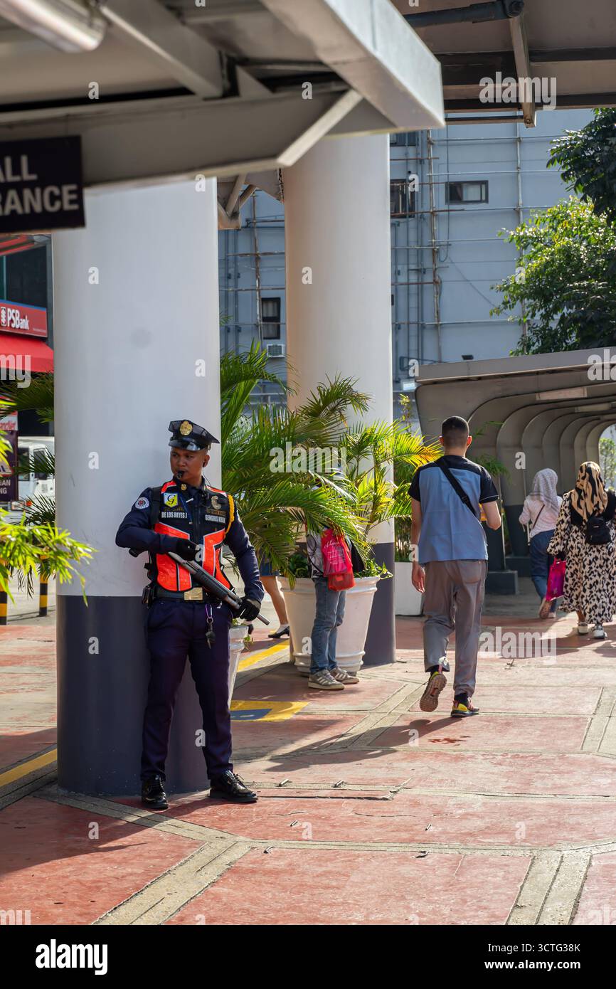 a security guard in uniform armed with a shotgun standing in front of a ...