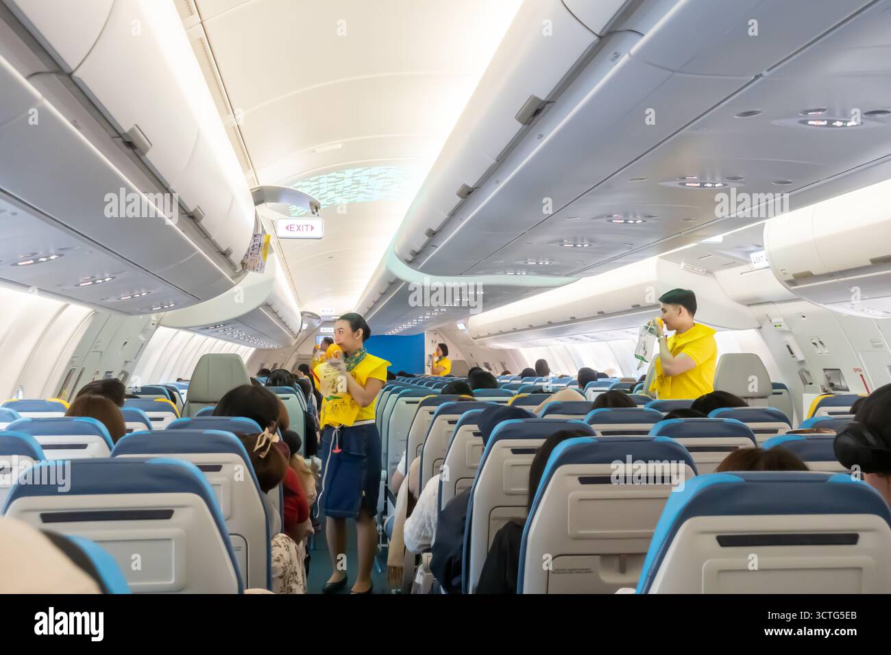 Cabin crew members, flight attendants, demonstrate oxygen mask use, in ...
