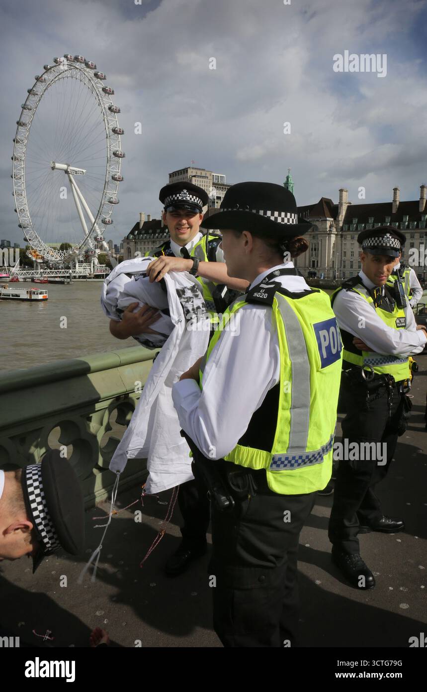 A police officer rolls one of the banners during the protest ...