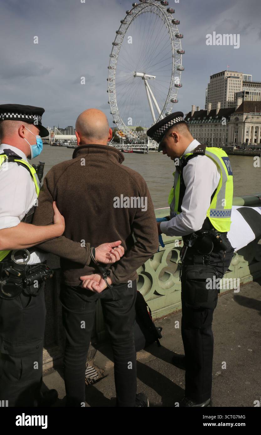 Police officers arrest an activist for supporting a banned group during ...