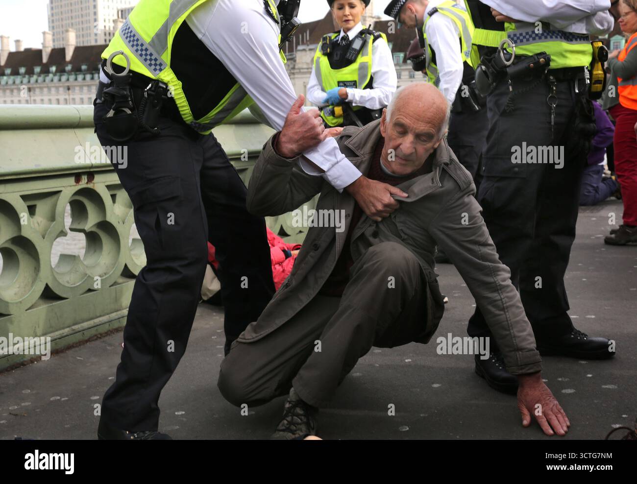 A police officer grabs an activist by the collar during the protest ...