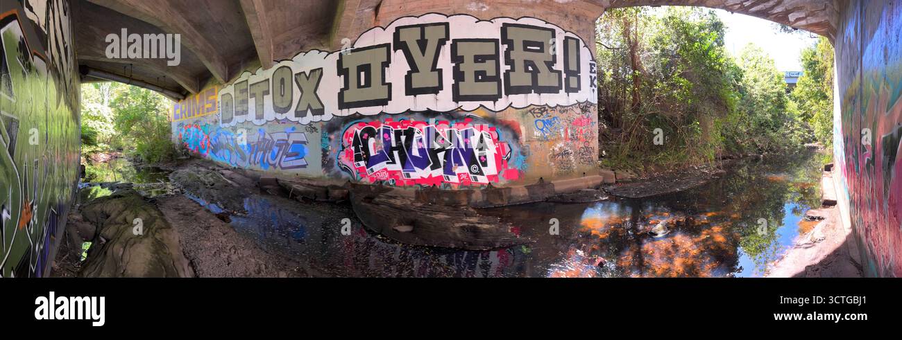 Graffiti art underneath culverts over creek on the M5, Sydney, NSW ...