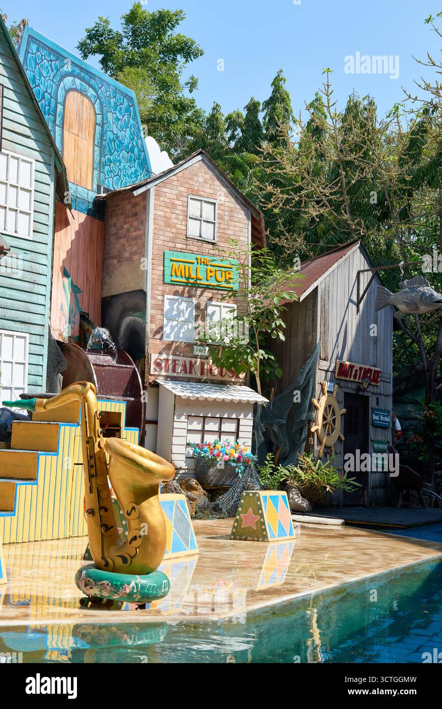 Brightly colored buildings surround a sparkling pool, with whimsical ...