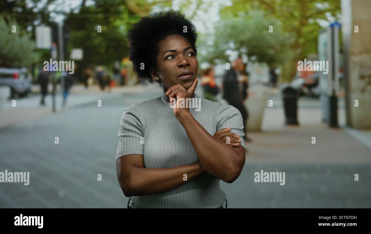 Woman contemplating idea on a vibrant city street, showcasing ...
