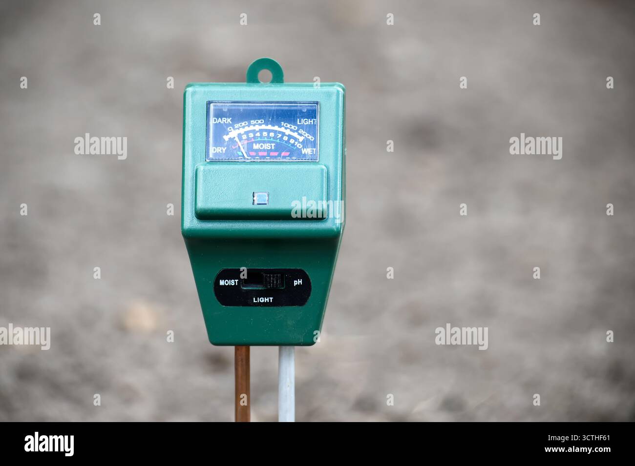 The green meter is inserted into the soil, providing readings for ...
