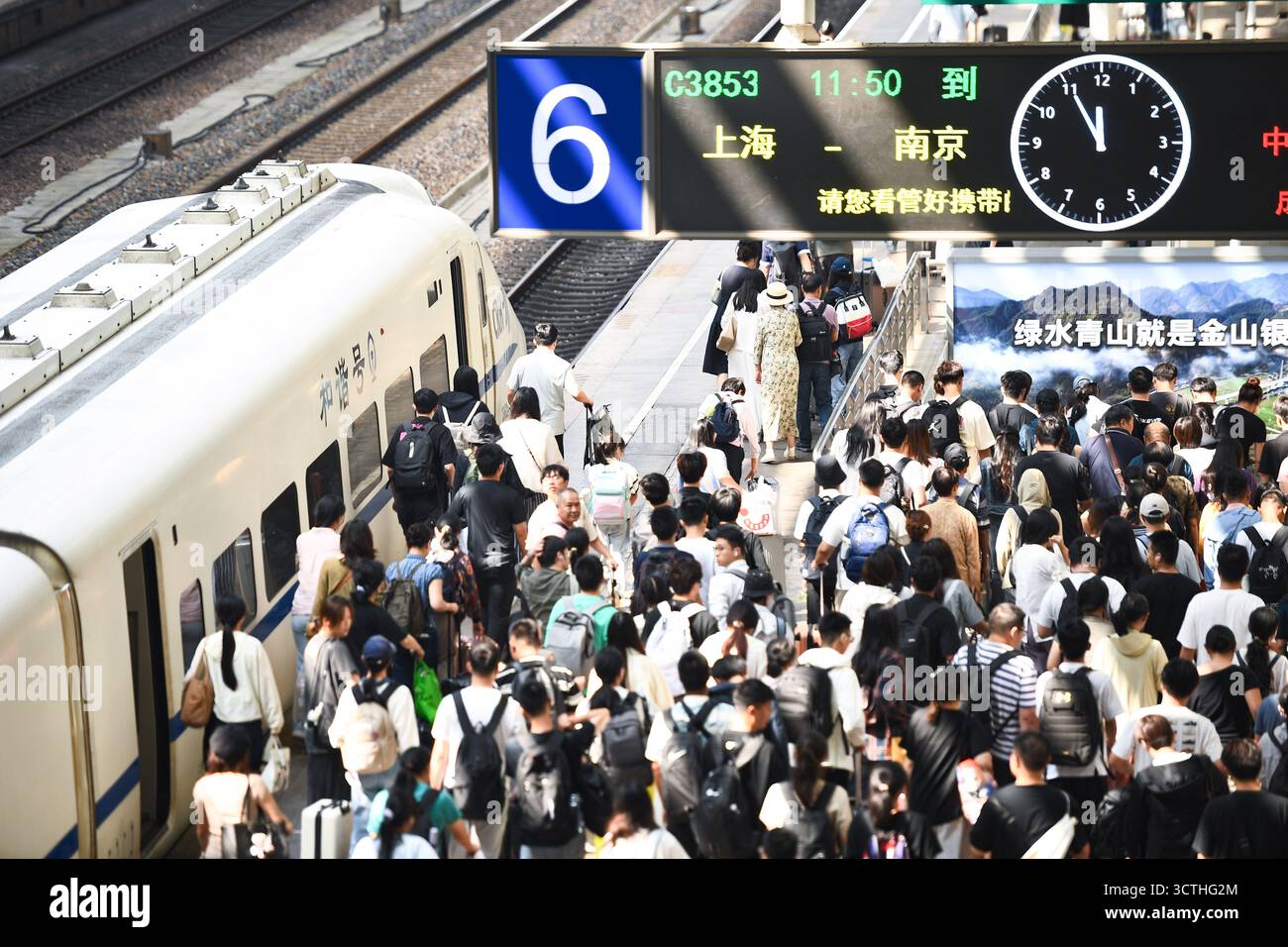 Travelers walk down stairs on a platform at a railway station in ...
