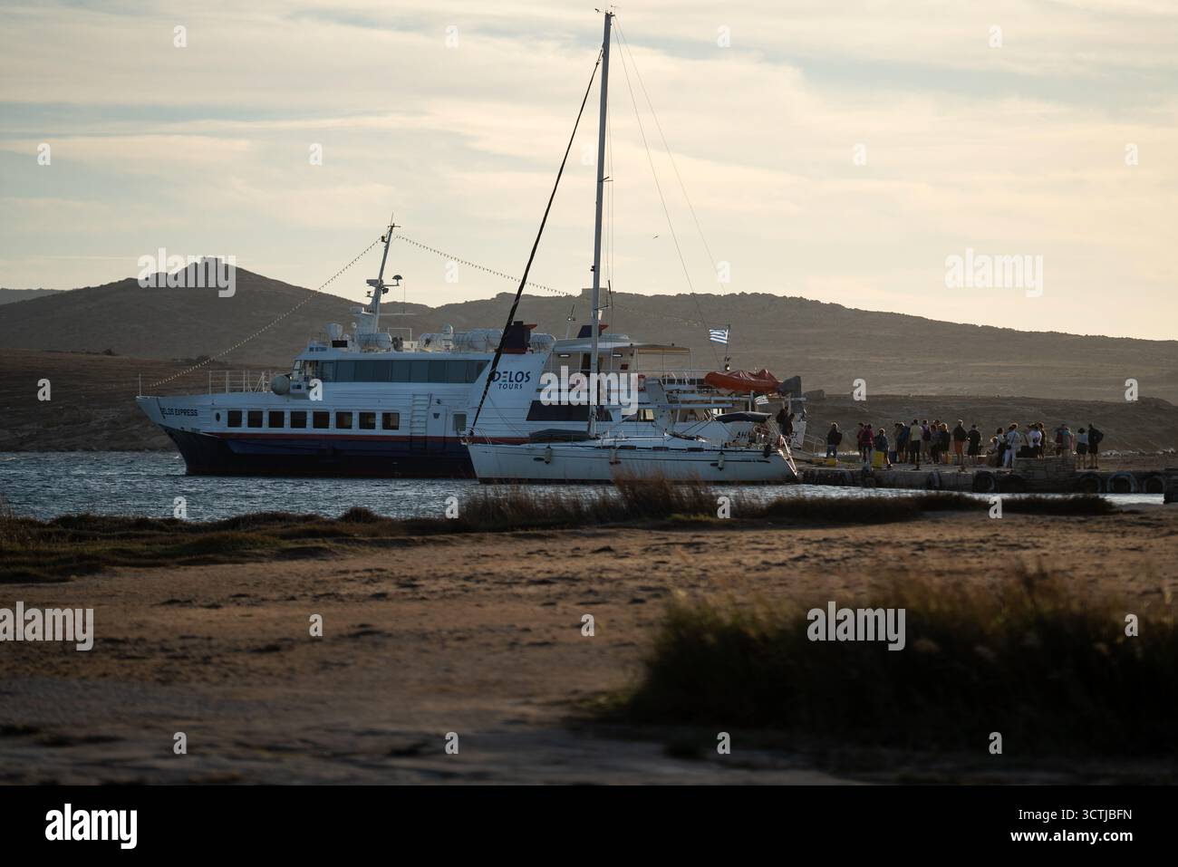 Tourists board the boat back to Mykonos after a visit to the sacred ...