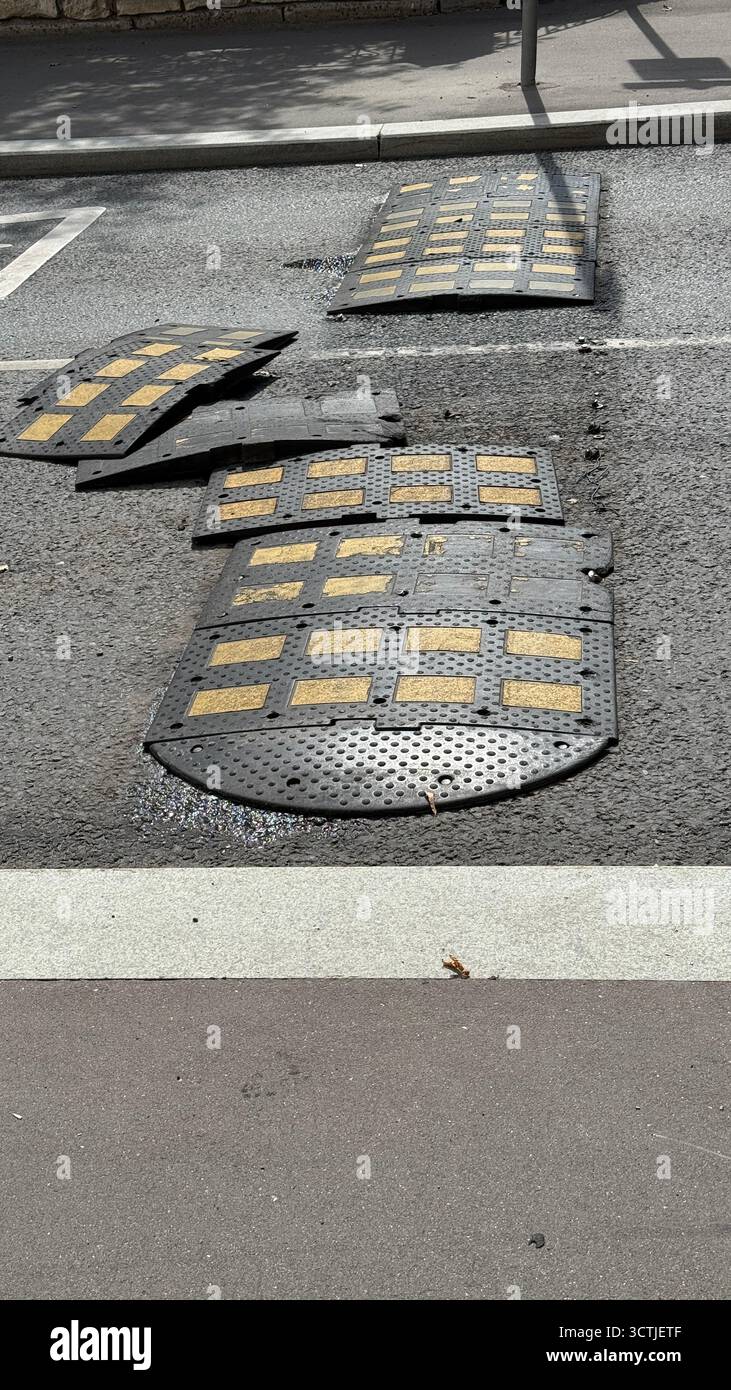 Damaged speed bumps on urban road with sunlight creating textures ...