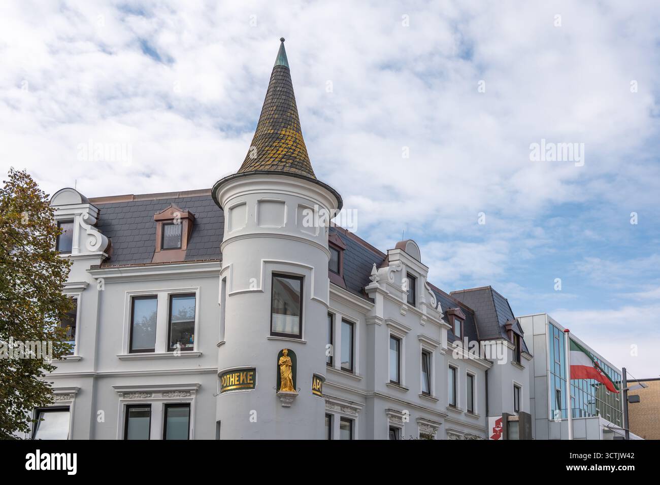 A historic corner building with a turret and ornate white fasade houses ...