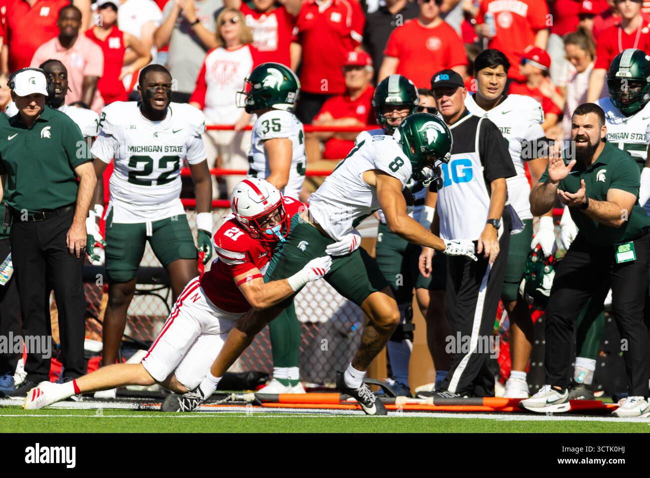 Nebraska defensive back Rex Guthrie (21) tackles Michigan State wide ...