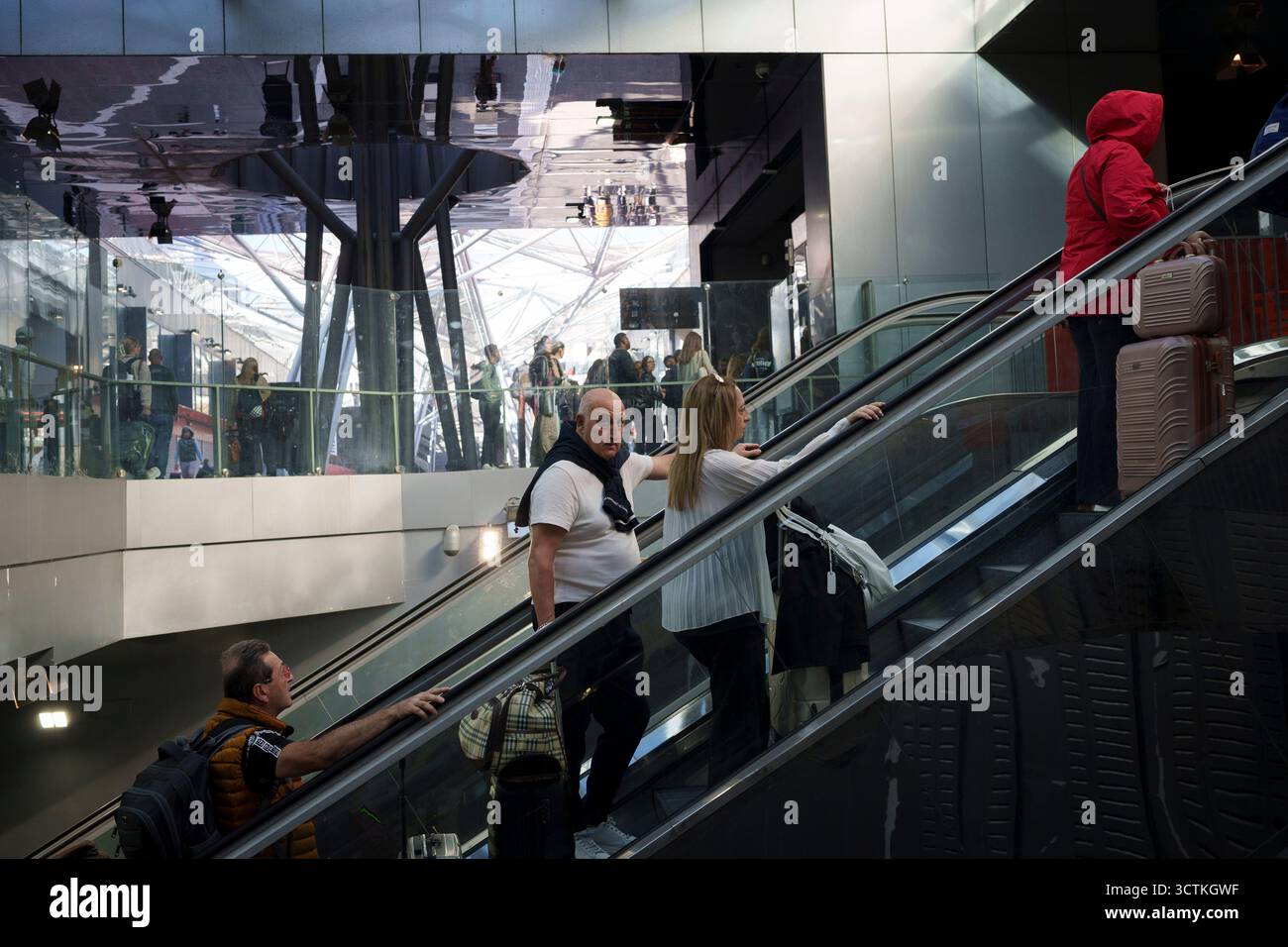 Travellers and passengers take the escalator through an underground ...