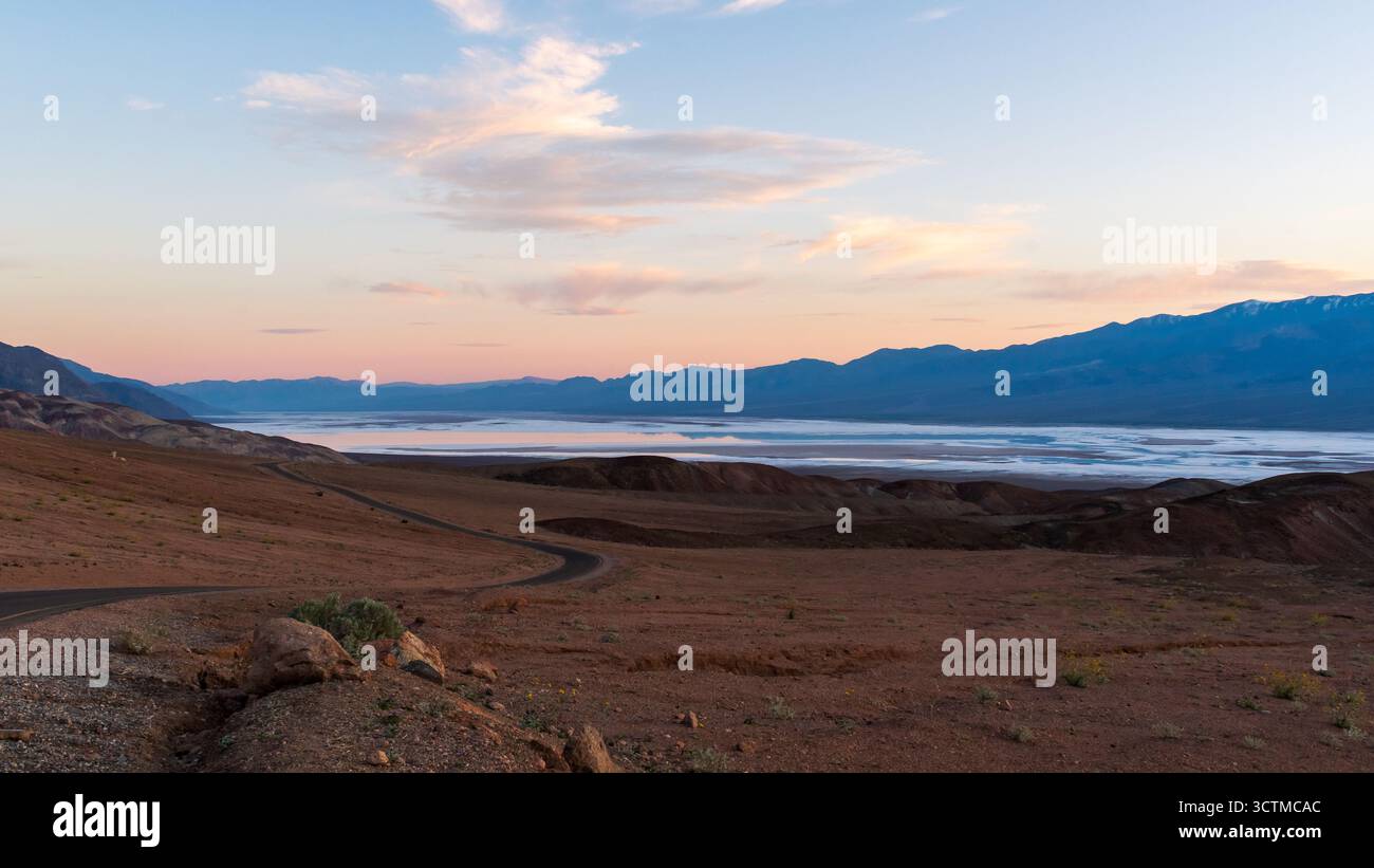 Reflections in Lake Manly and salt flats at sunset in Death Valley with ...