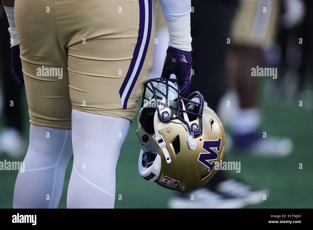 Washington defensive lineman Bryce Butler holds his helmet on the ...