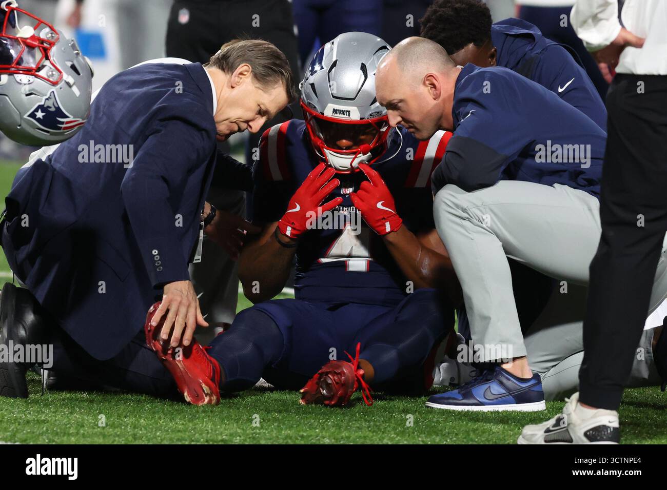 New England Patriots running back Antonio Gibson (4) is looked at by ...