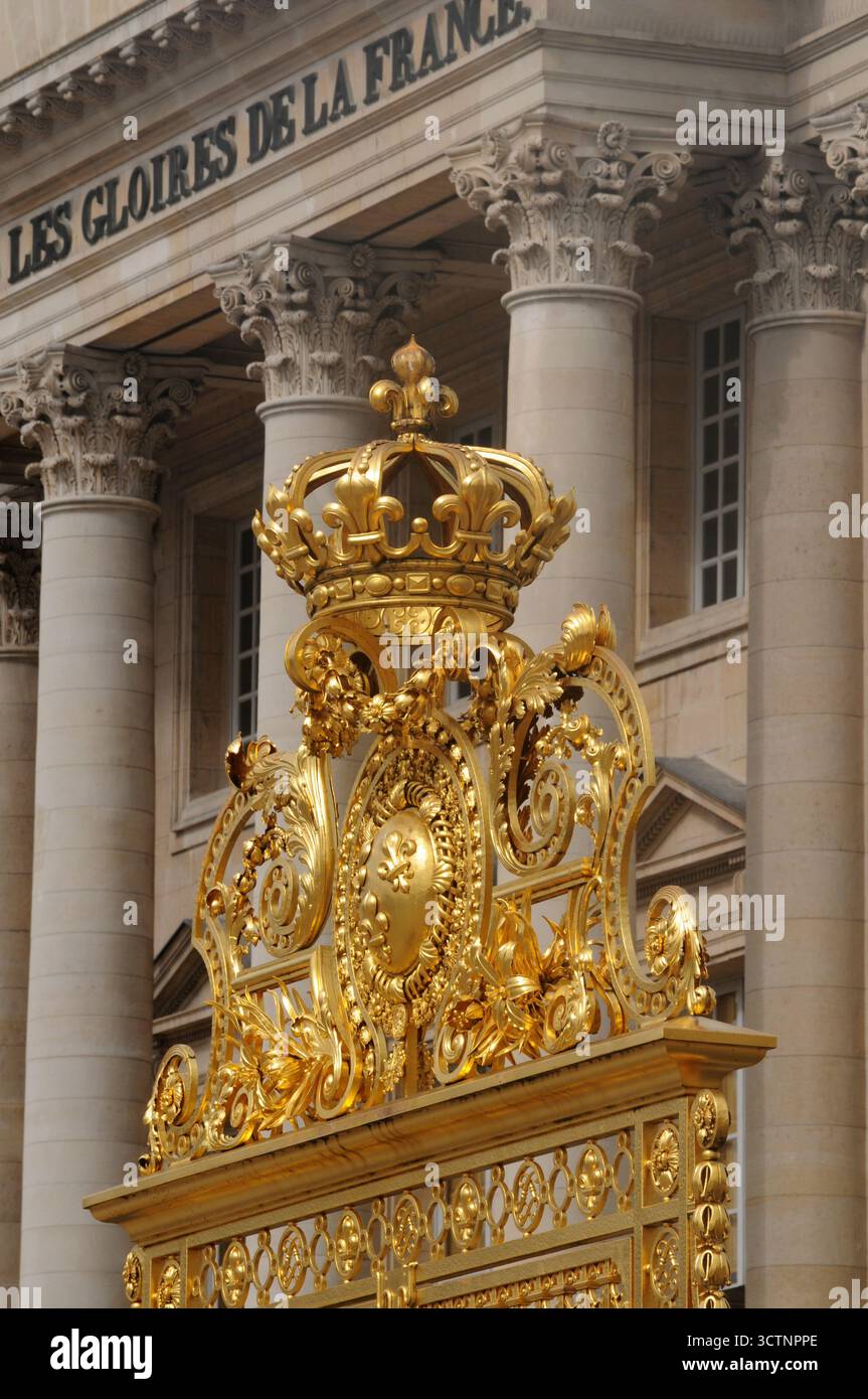 Ornate gold crown decoration on top of golden gates at the entrance to ...