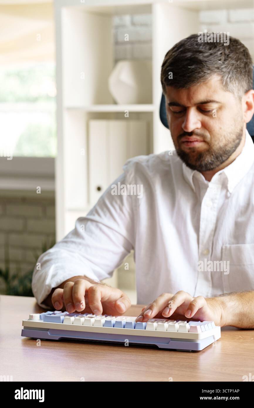 Man using a mechanical keyboard while focused on work at a home office ...