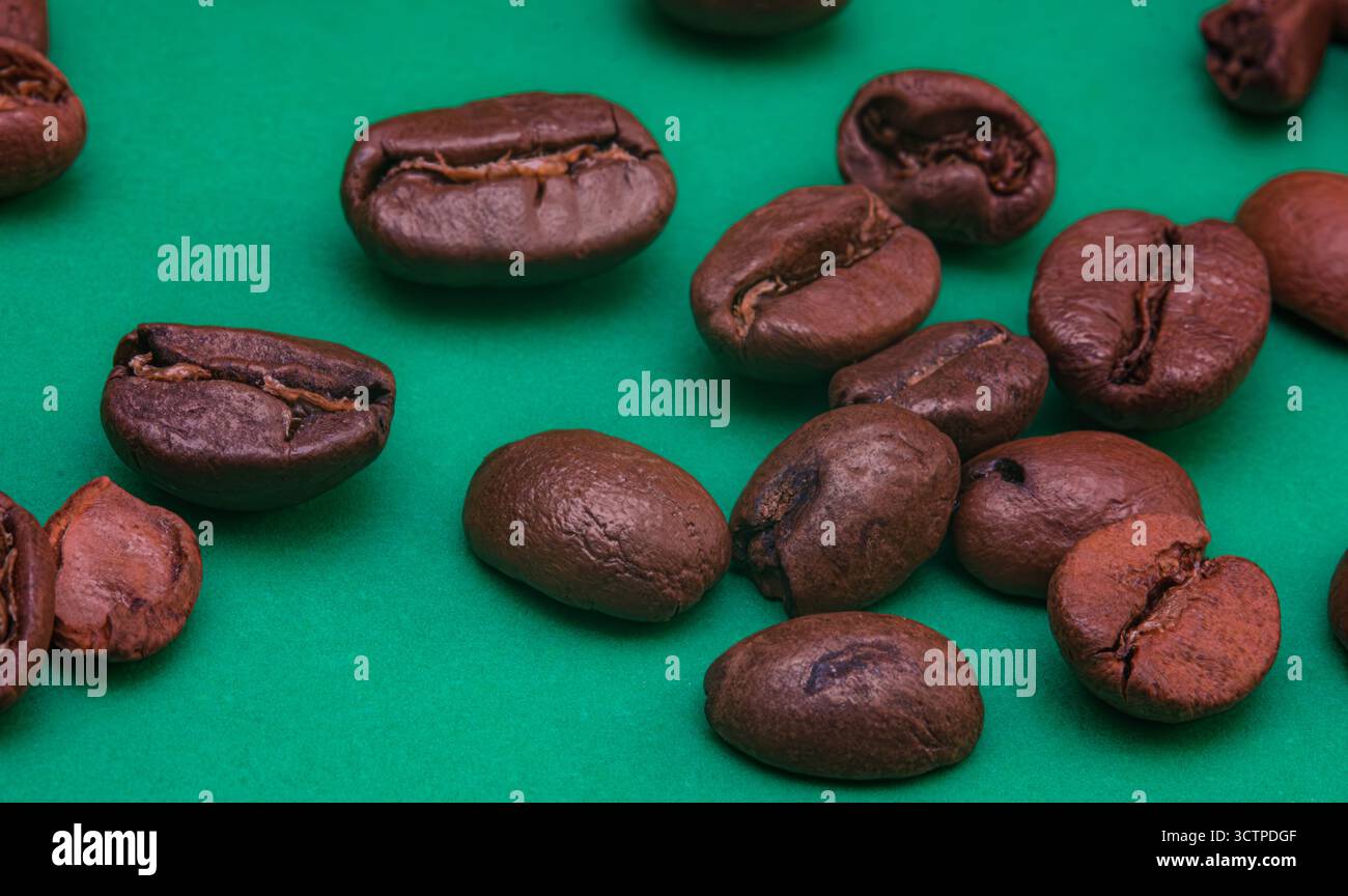 Roasted coffee beans vibrant green background. Close-up of roasted ...