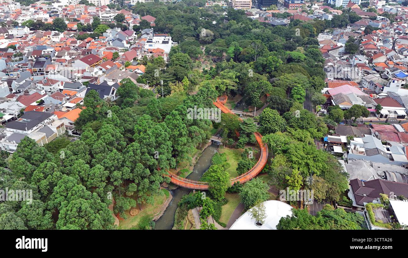 Aerial view of a vibrant orange pedestrian bridge curves gracefully ...