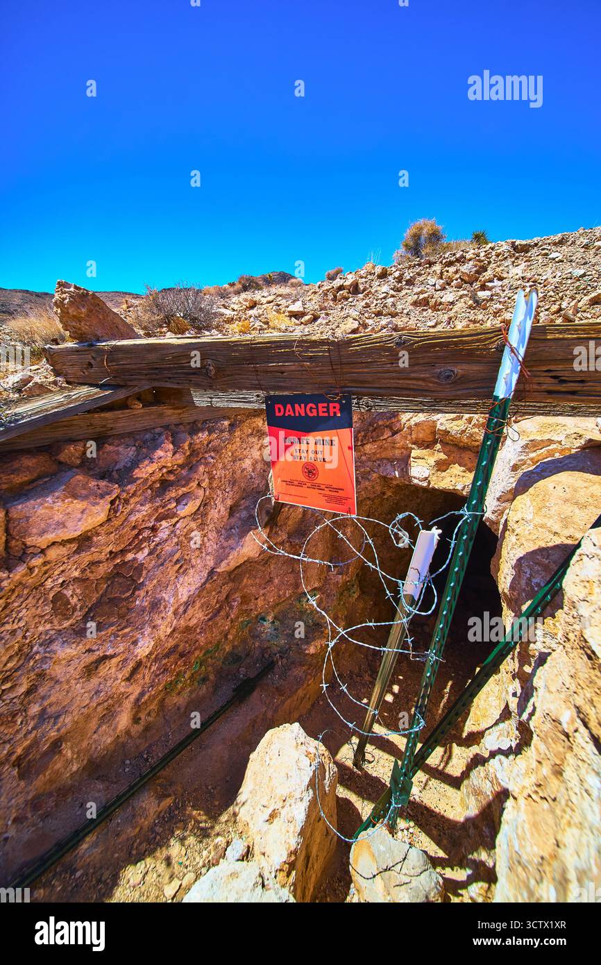 Abandoned Mine Entrance with Warning Sign and Barbed Wire in Desert ...
