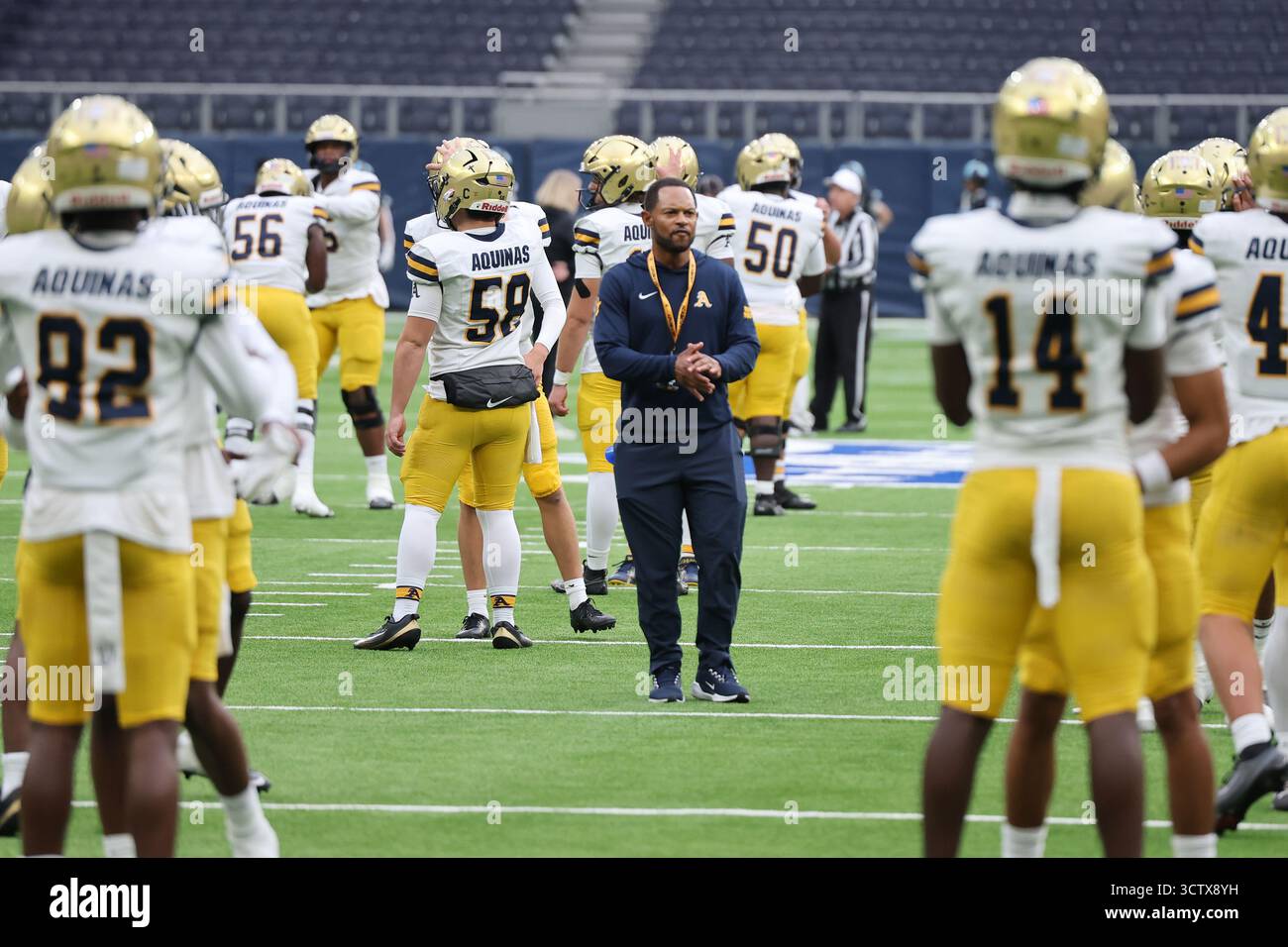 St. Thomas Aquinas head coach Roger Harriott watches his team warm up ...