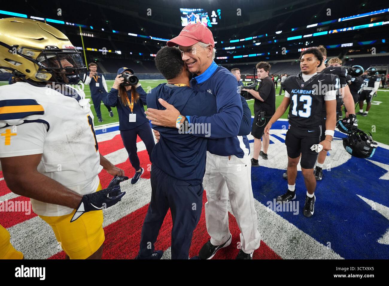 St. Thomas Aquinas head coach Roger Harriott, hugs NFL Academy head ...