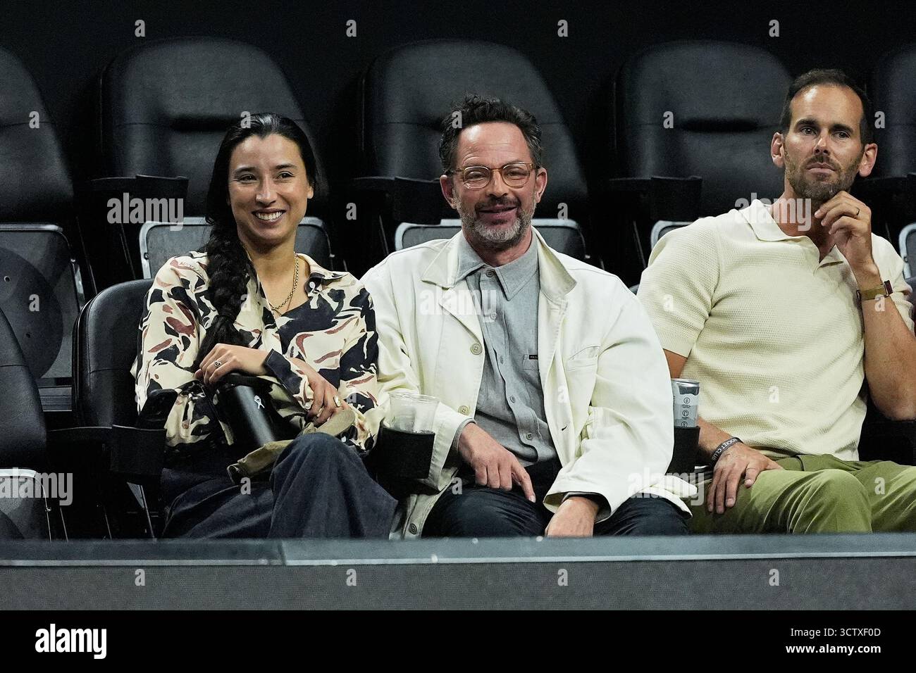 Actor Nick Kroll, middle, and his wife, Lily Kwong, left, watch matches ...