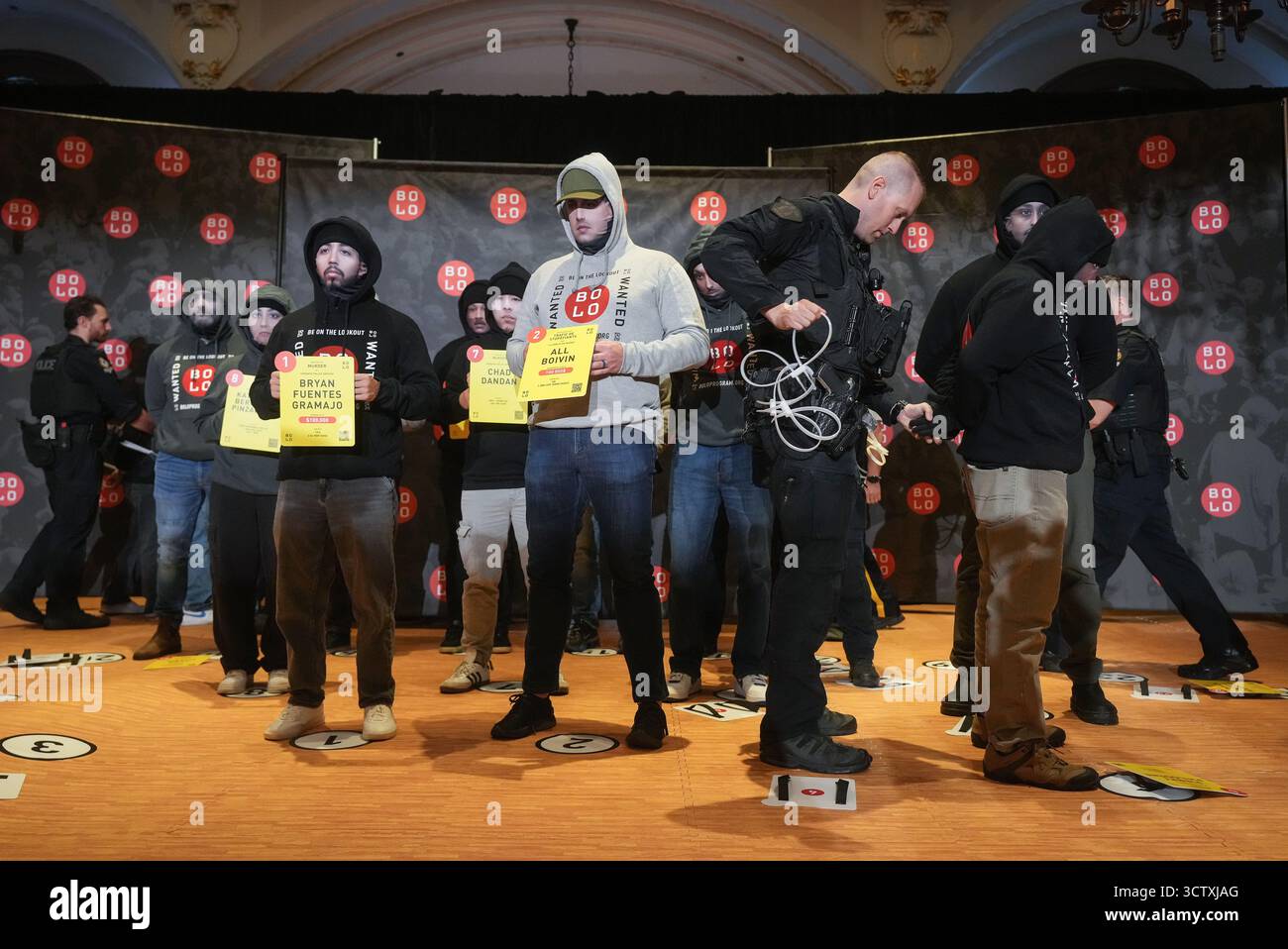 Police officers acting as models wearing masks bearing the faces of ...