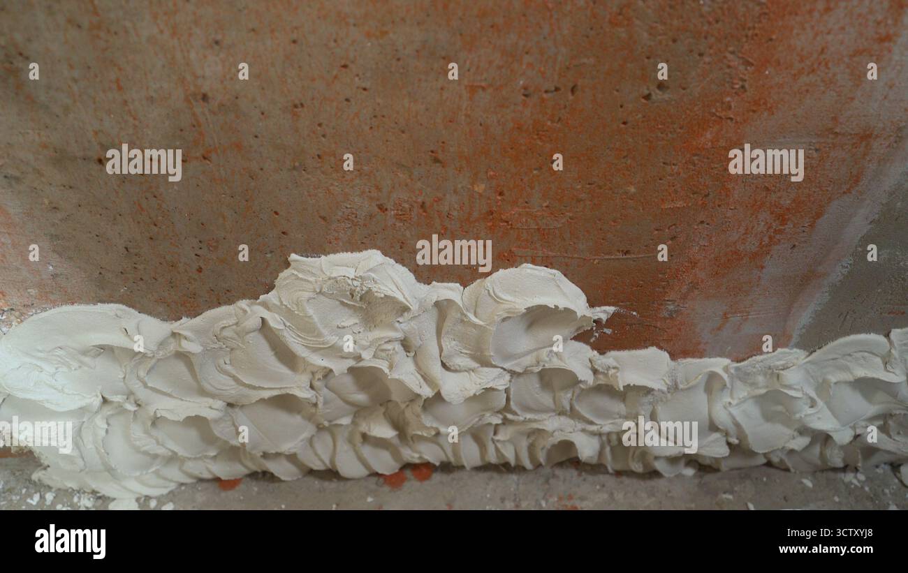 Applying gypsum filler material to a brick wall joint, sealing gap and ...