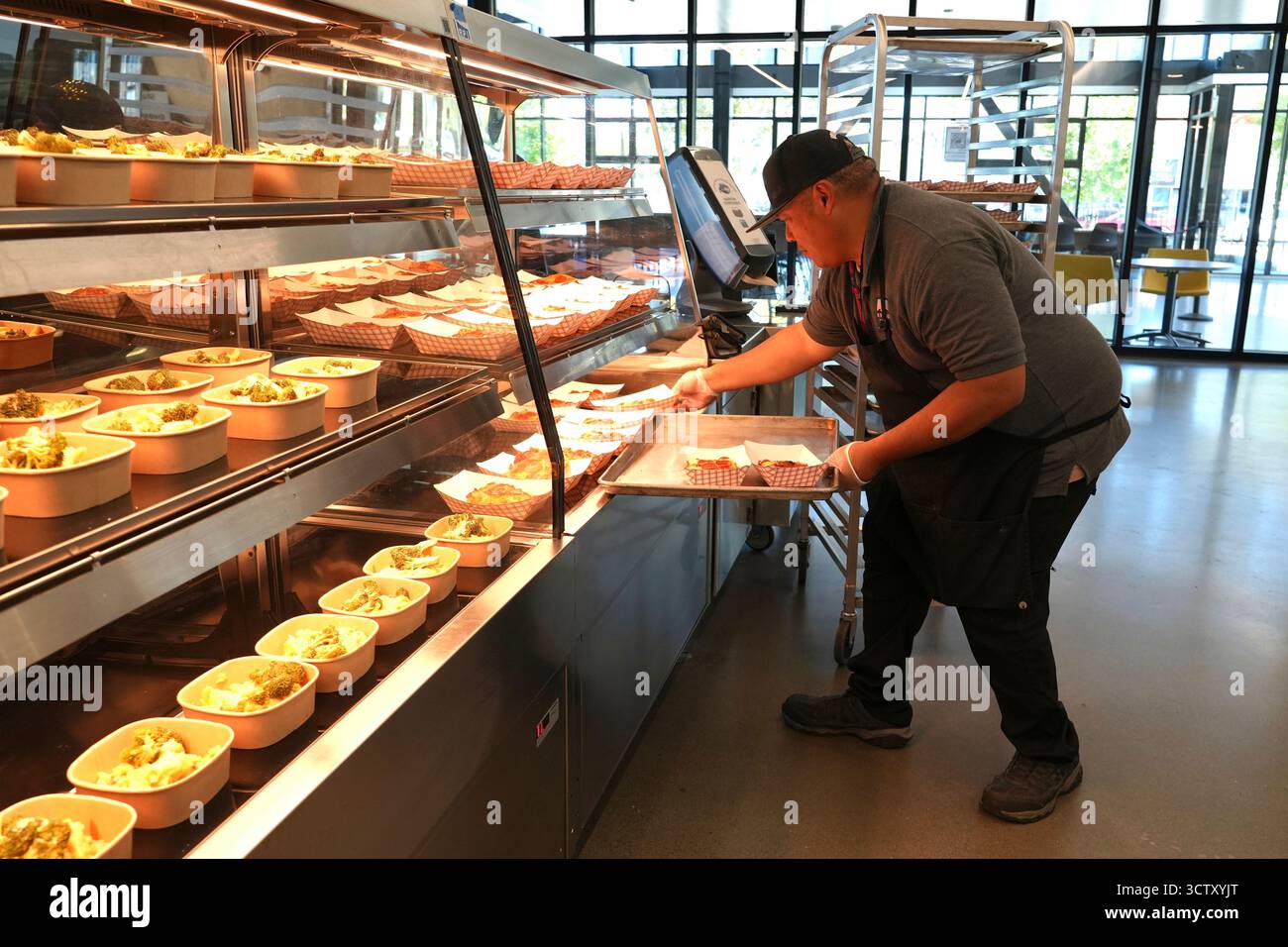 School cook Mark Pagaran puts out freshly-made pizza in the cafeteria ...