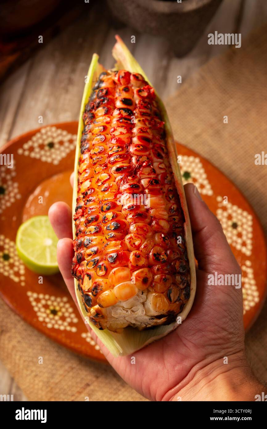 Hand holding roasted elote corn hi-res stock photography and images - Alamy