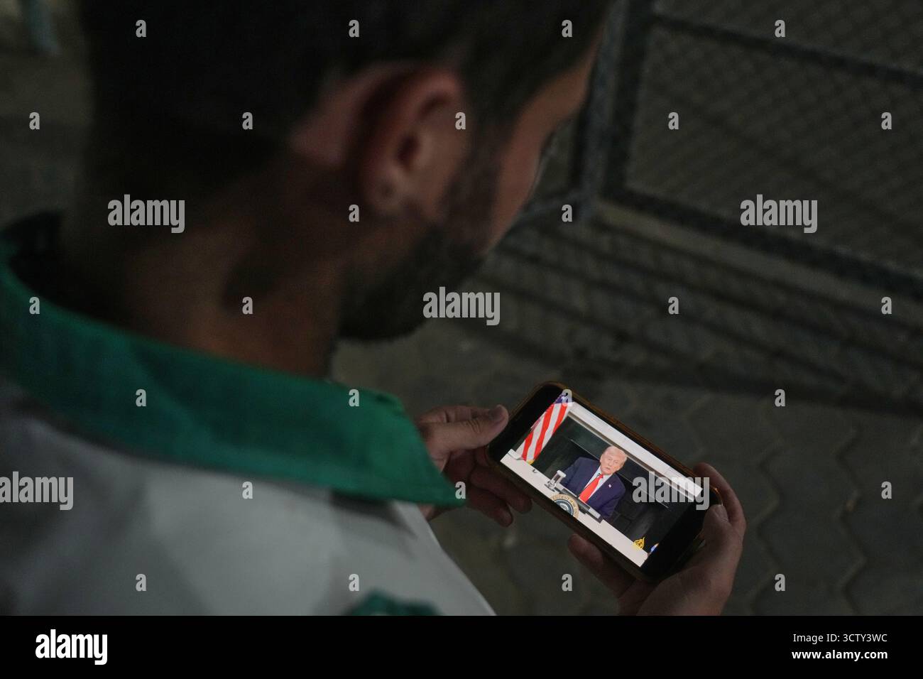 Palestinian paramedic Saeed Awad looks at his phone displaying an image ...