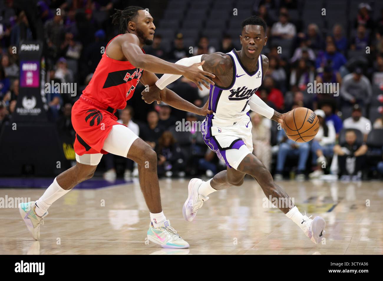 Sacramento Kings guard Dennis Schroder, right, dribble around Toronto ...